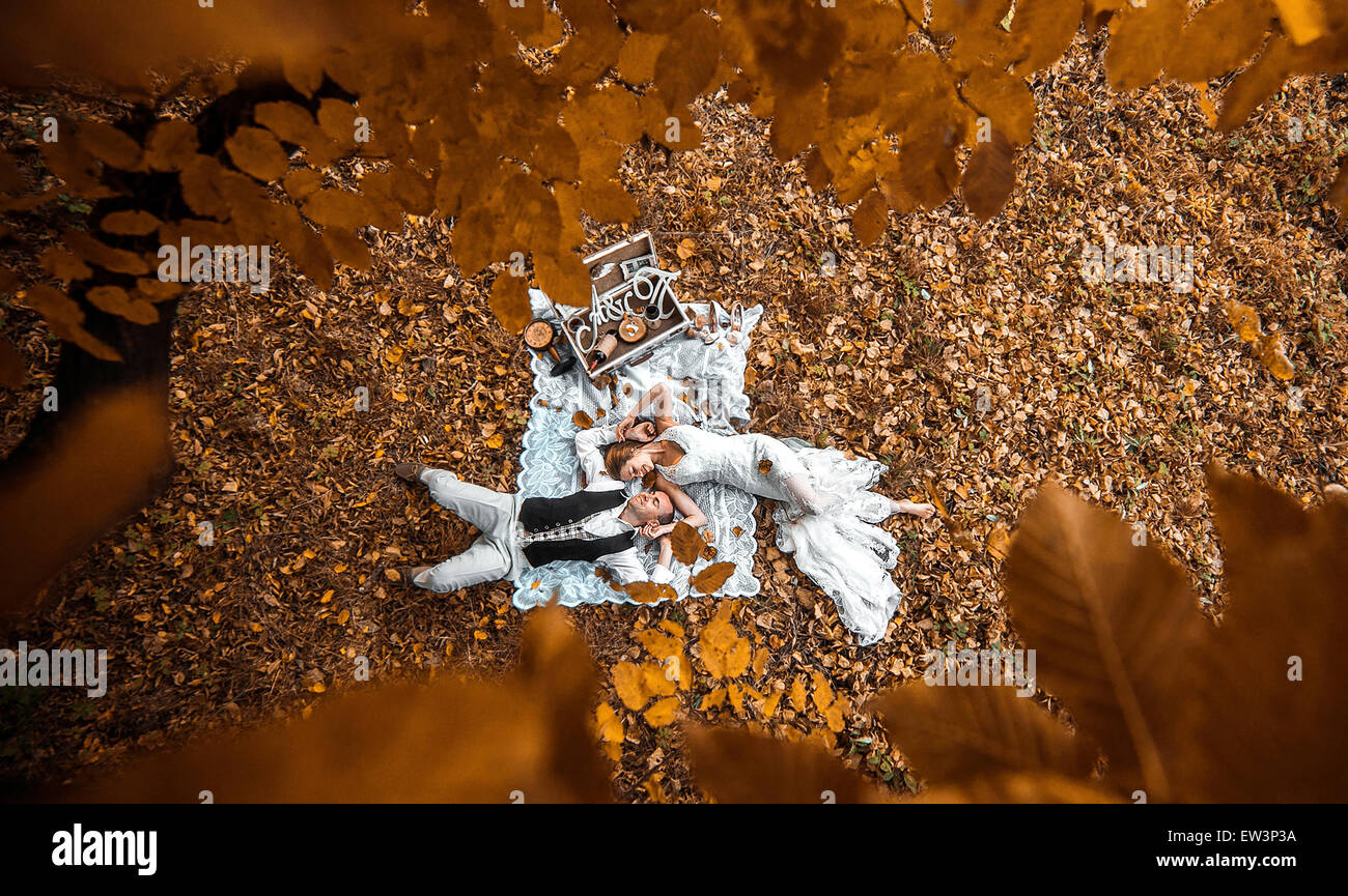 wedding couple lying under a tree Stock Photo - Alamy