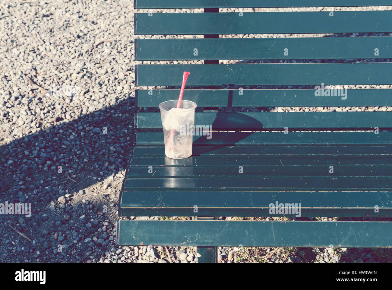 disposable plastic drinks cup with straw lying on bench Stock Photo - Alamy