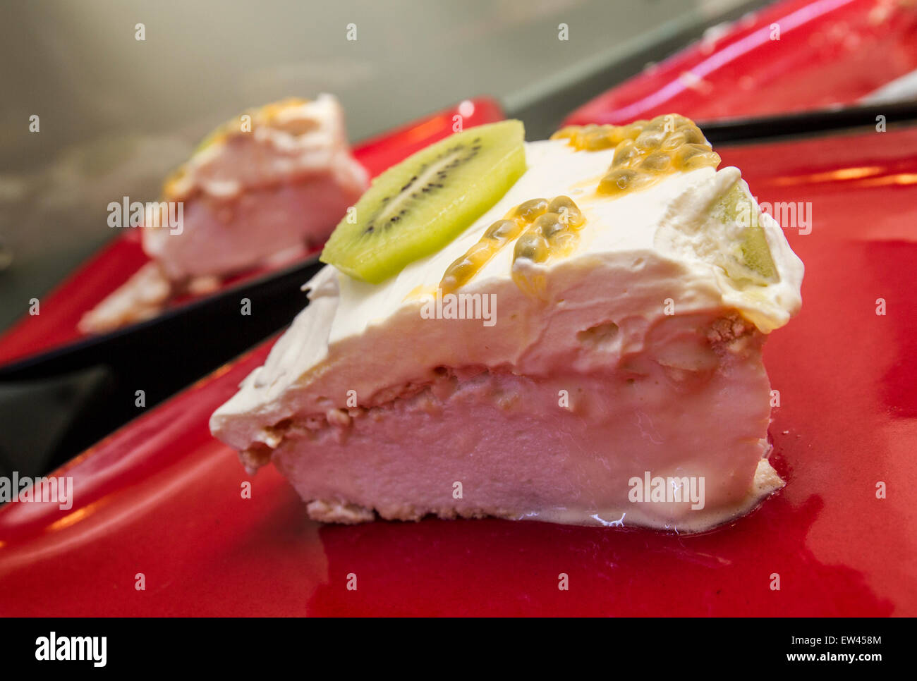 slice of pavlova on red plate with fruit Stock Photo - Alamy