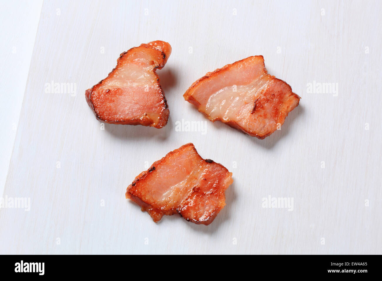 Pieces of pan fried bacon Stock Photo - Alamy