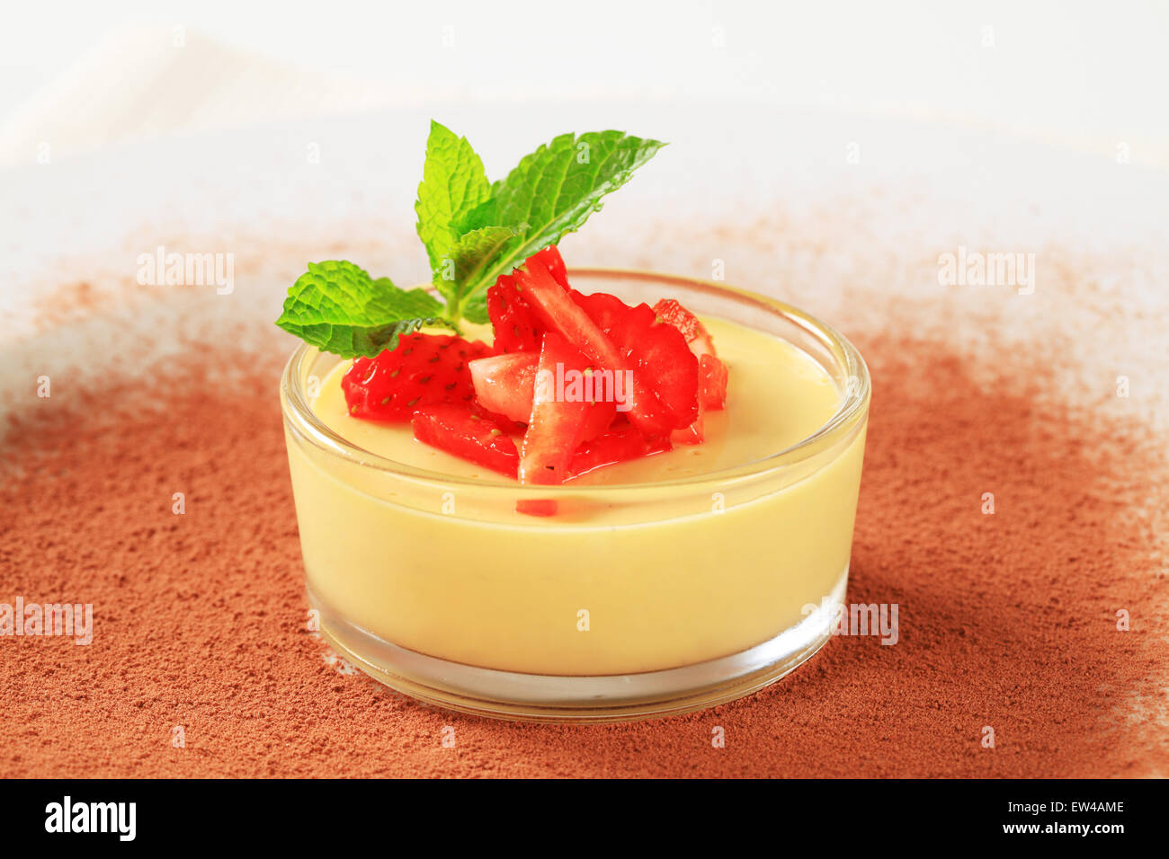 Small dish of custard topped with strawberry Stock Photo - Alamy