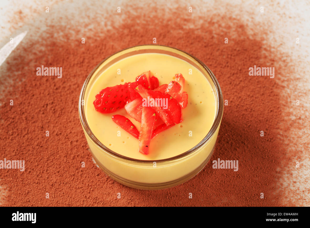 Small dish of custard topped with strawberry Stock Photo - Alamy