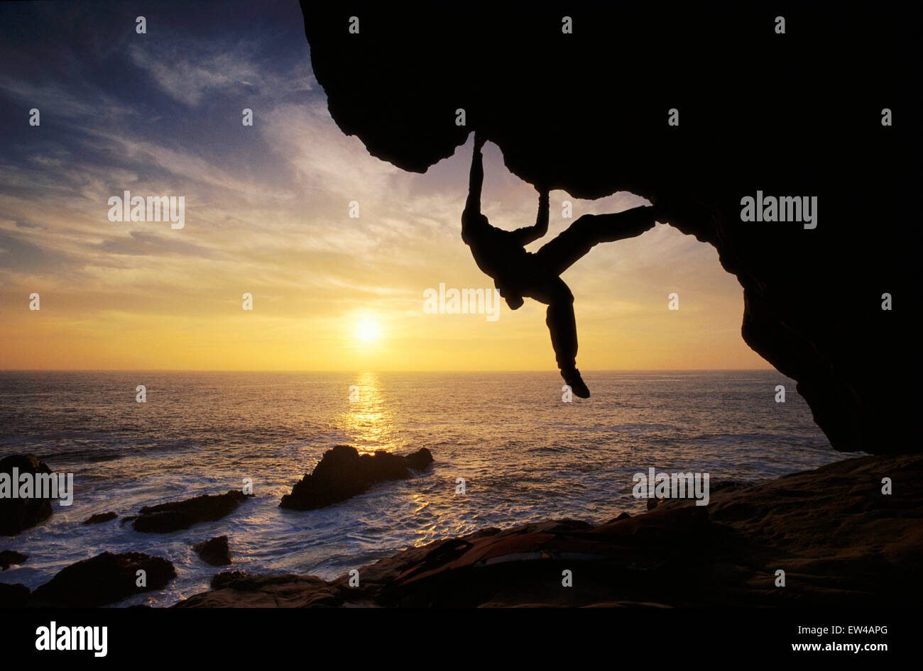 Climber silhouetted over the ocean at sunset Stock Photo - Alamy