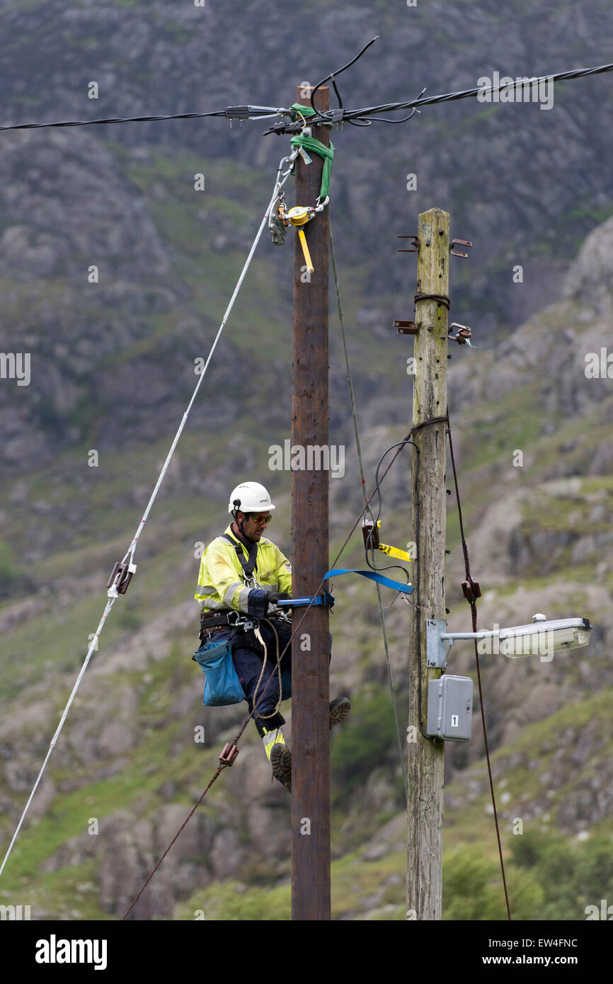 An engineer carries out maintenance on a electricity utility pole in ...