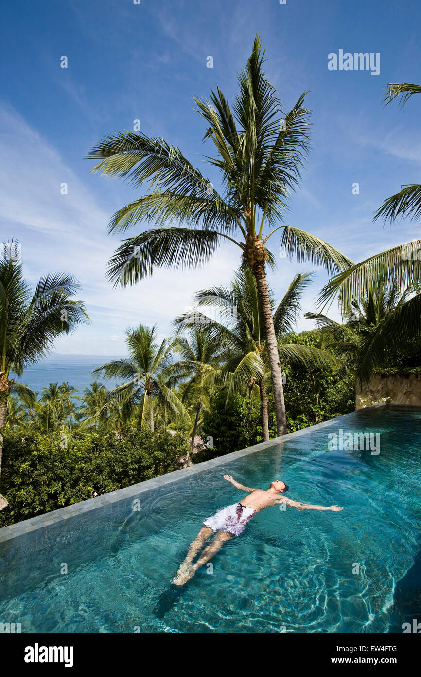A man floating in an infinity pool Stock Photo - Alamy