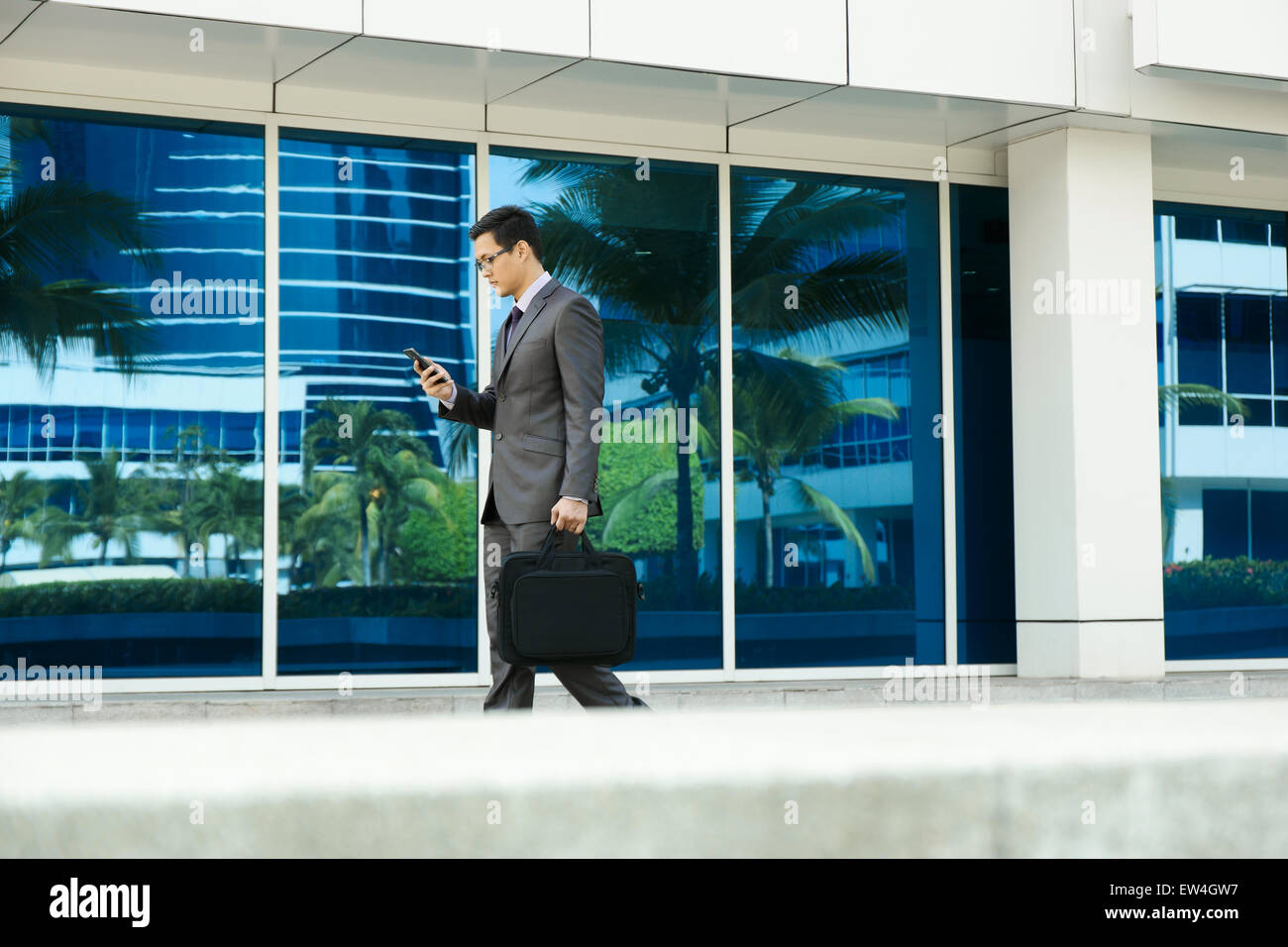 Young chinese businessman commuting to office with computer bag and ...