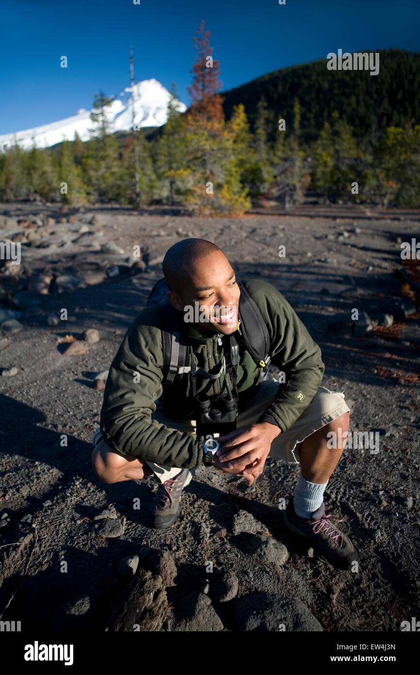 African American man Cupid Alexander rests while hiking near Mt. Hood ...