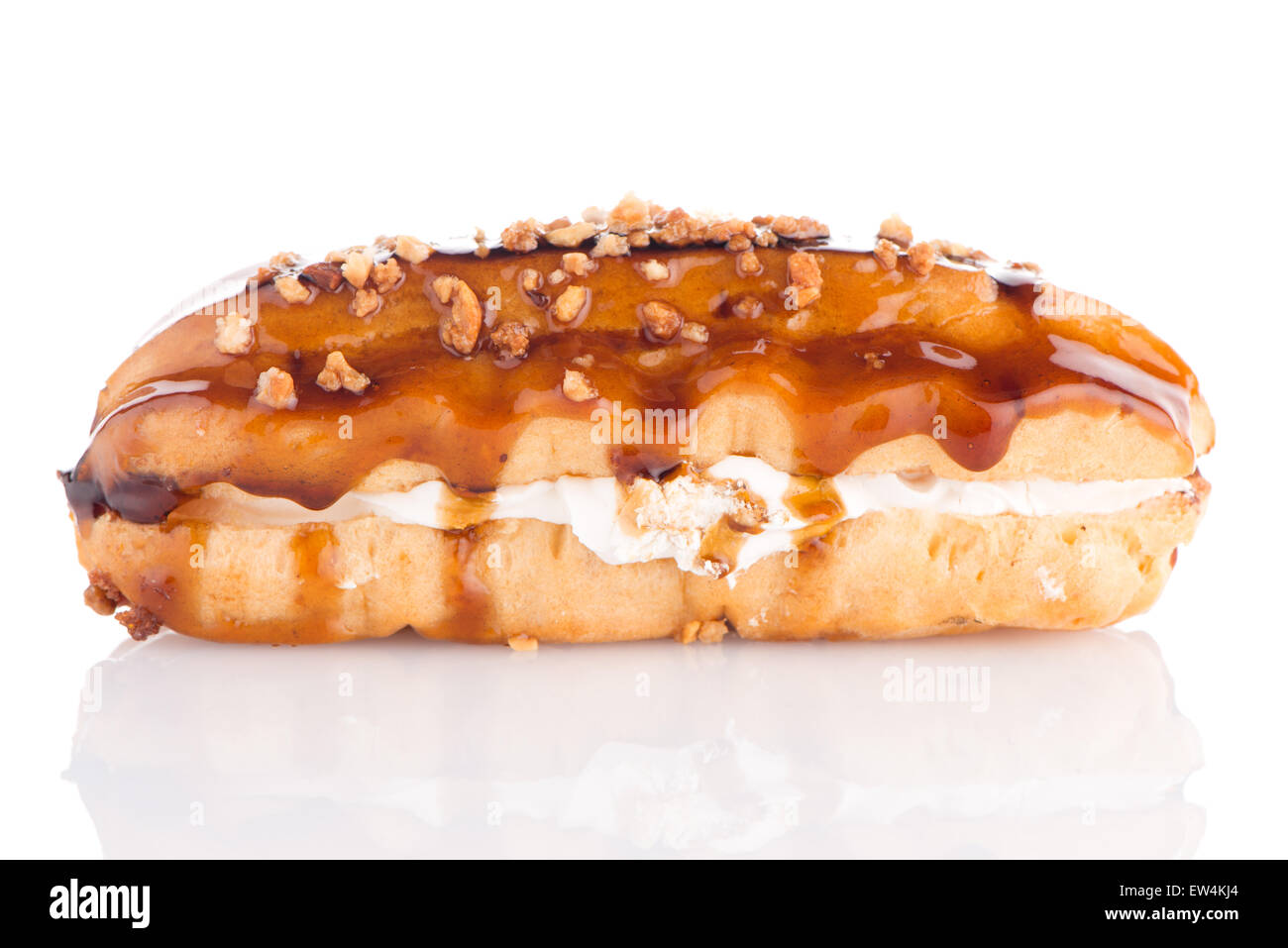 Eclair with caramel decoration on white reflective background Stock ...