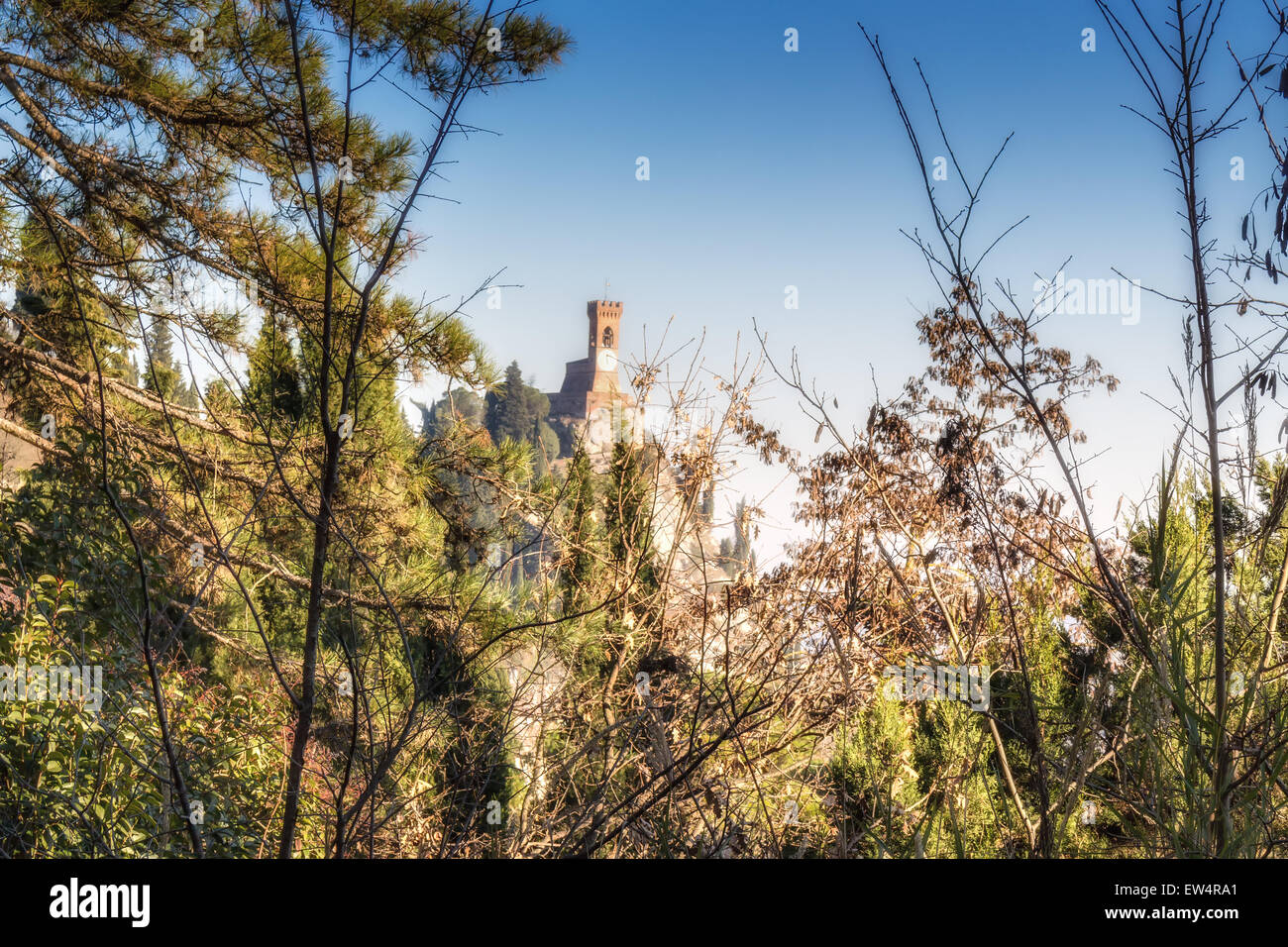 A medieval crenellated clock tower stands on a peak overlooking the ...