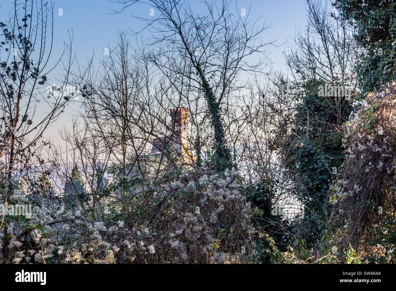 A medieval crenellated clock tower stands on a peak overlooking the ...