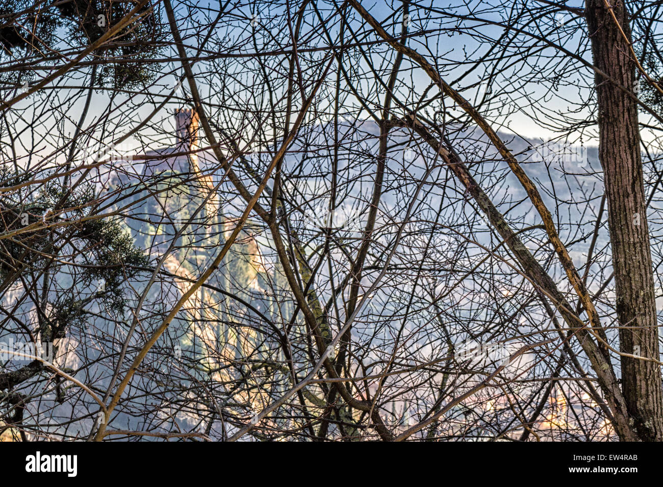 A medieval crenellated clock tower stands on a peak overlooking the ...