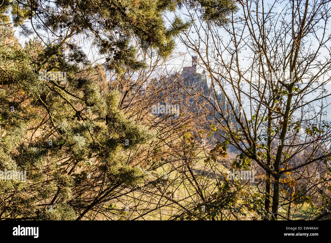 A medieval crenellated clock tower stands on a peak overlooking the ...