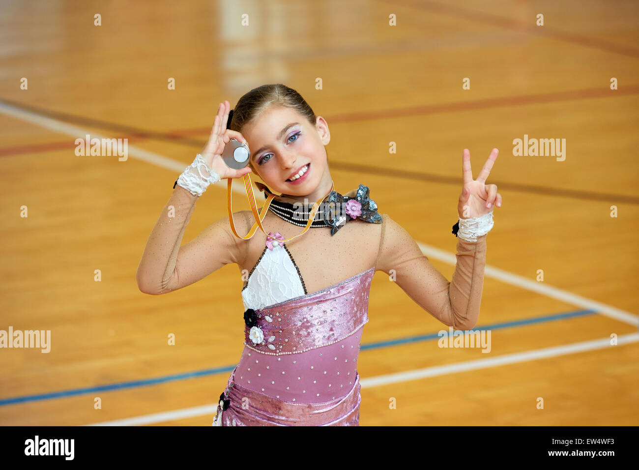 kid girl rhythmic gymnastics on wooden deck medal winner gesture Stock ...