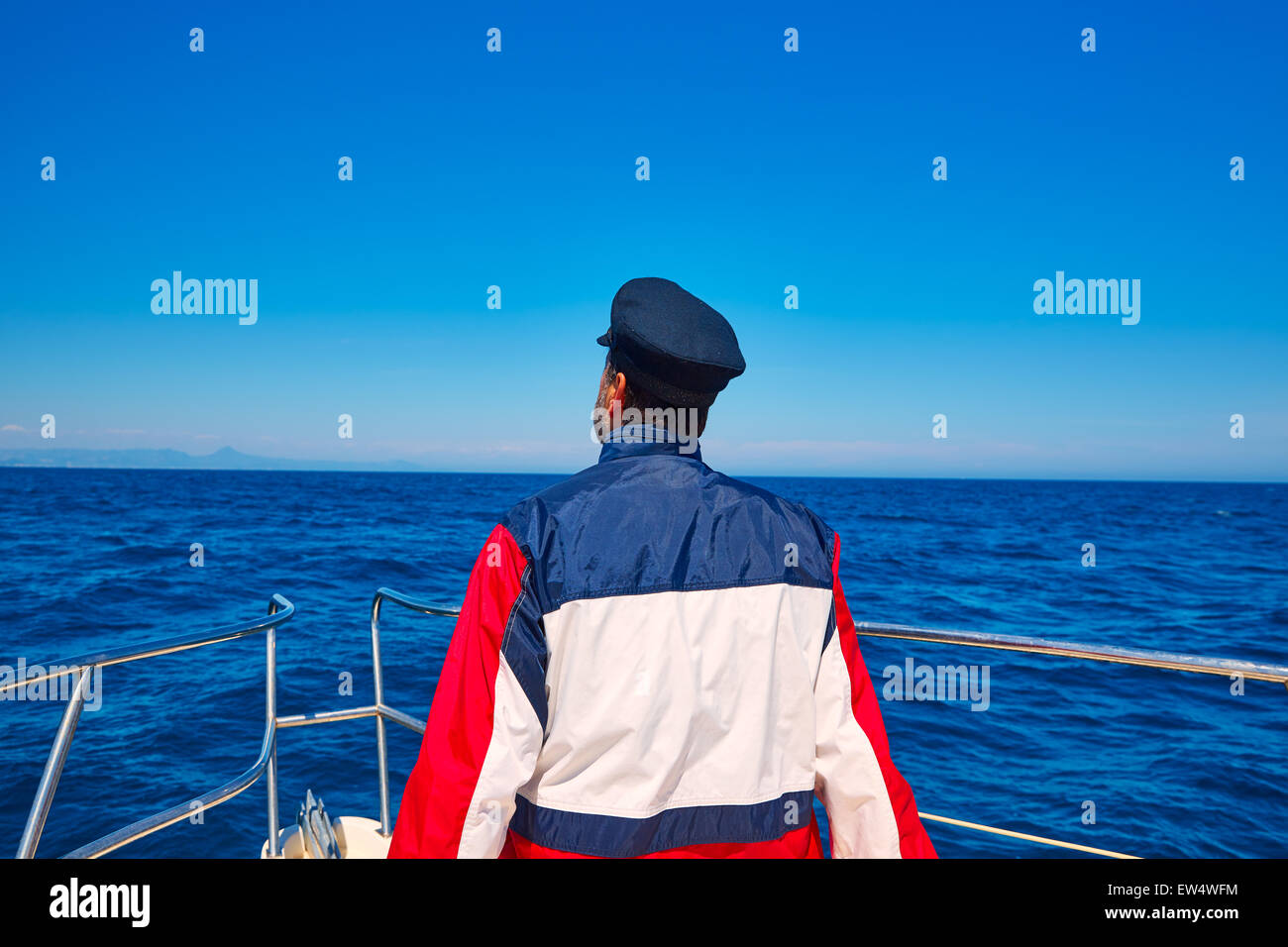 rear sailor man sailing sea ocean in a boat with captain cap looking ...