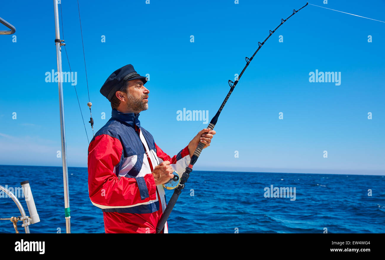 Beard sailor man fishing rod trolling in saltwater in a boat trolling ...
