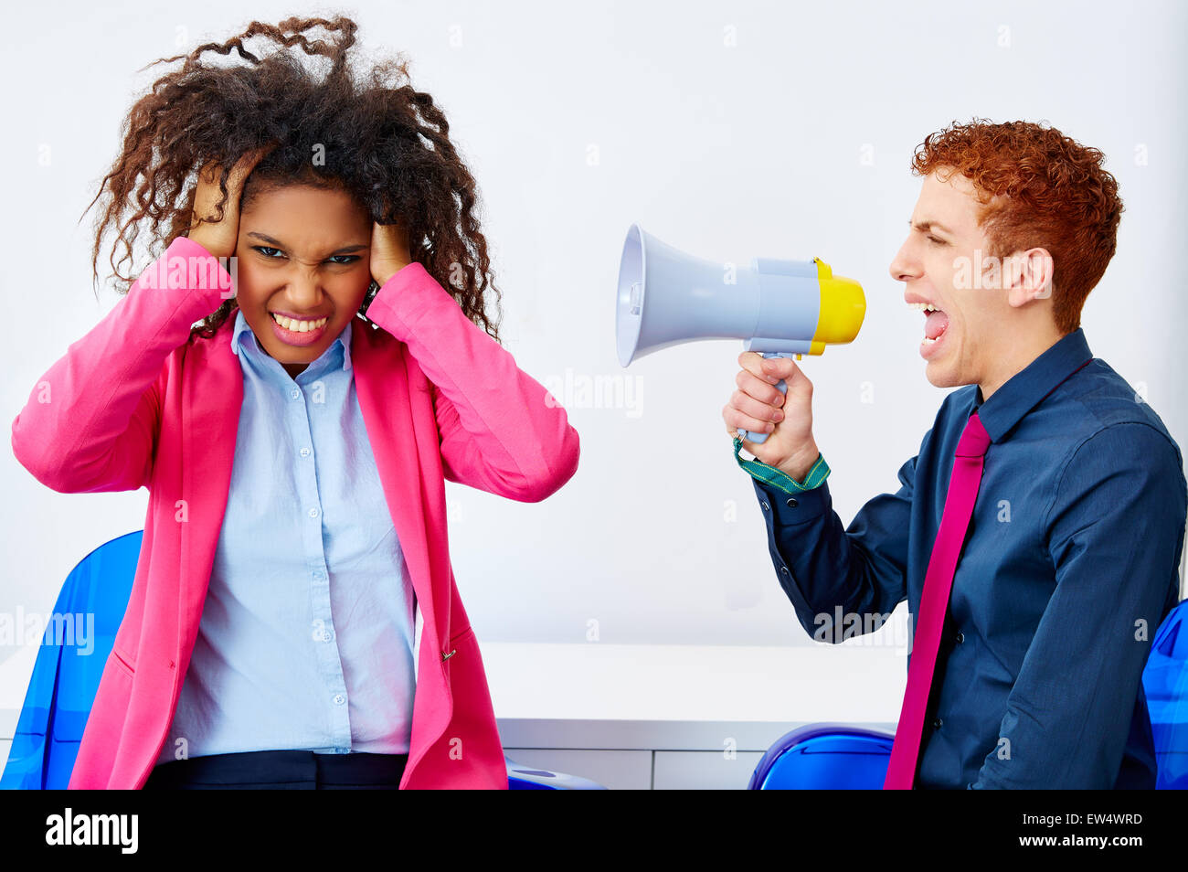 businessman shouting in megaphone to african executive with scared ...