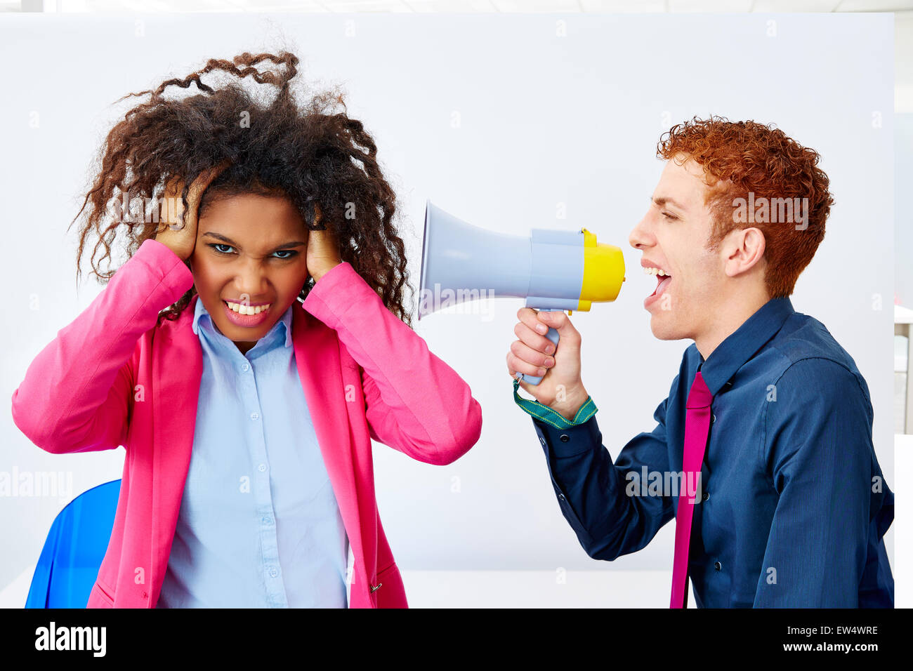 businessman talking in megaphone to african executive with scared ...
