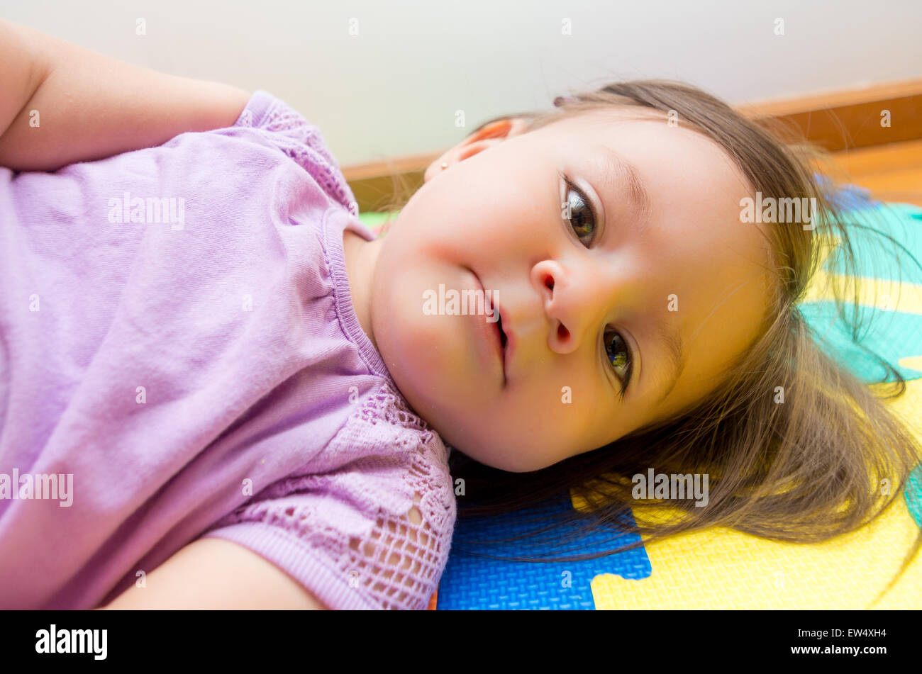 Adorable baby girl lying sideways Stock Photo - Alamy