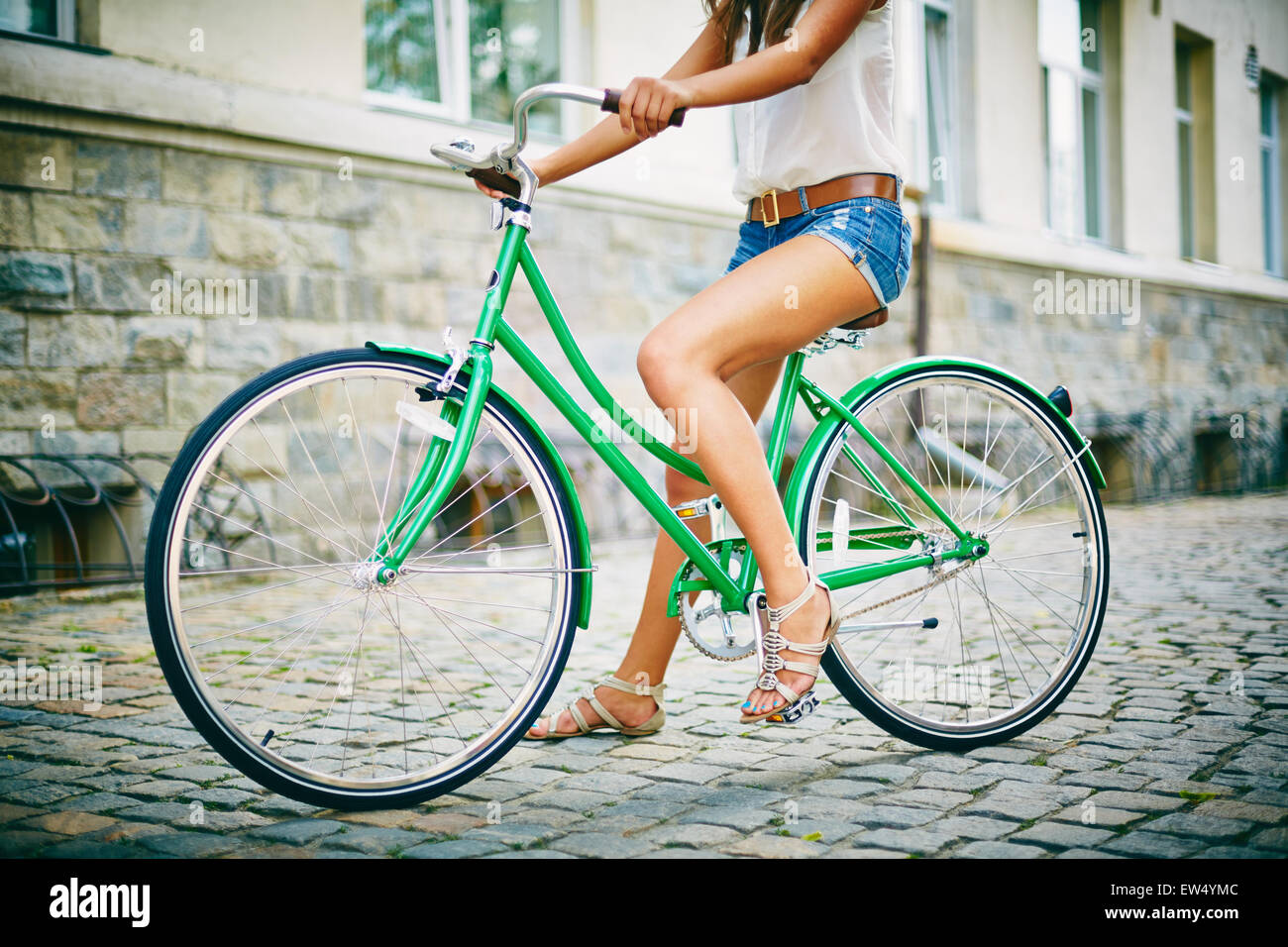 Legs of pretty girl sitting on bicycle in urban environment Stock Photo ...