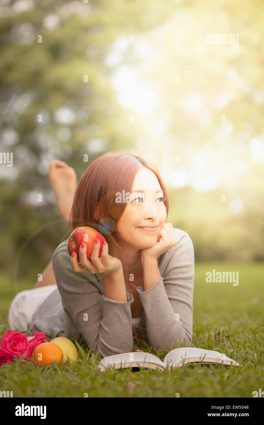 Young woman lying down on front and looking away with smile Stock Photo ...