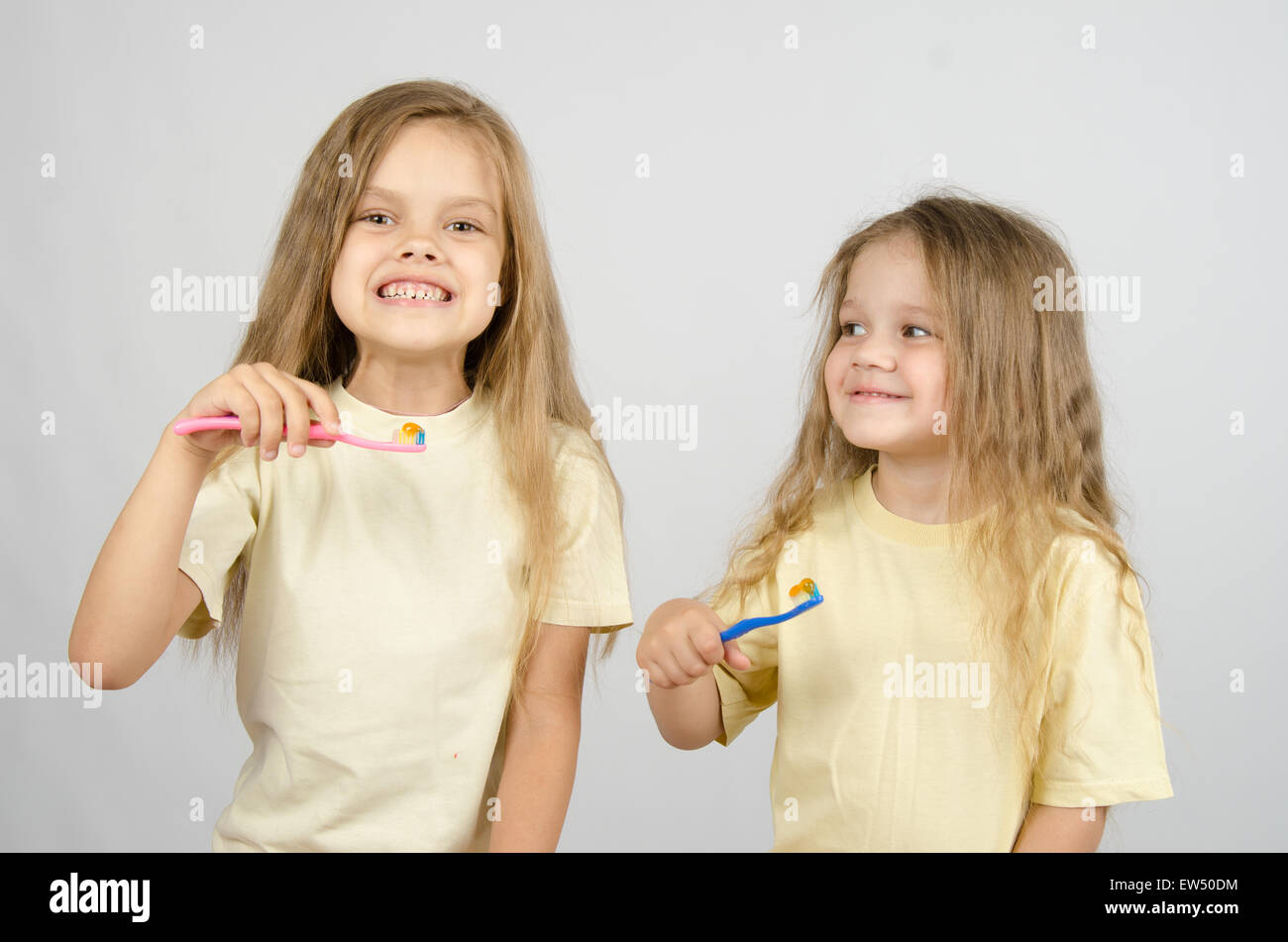 Two girls of four and six years of brushing their teeth toothbrushes ...