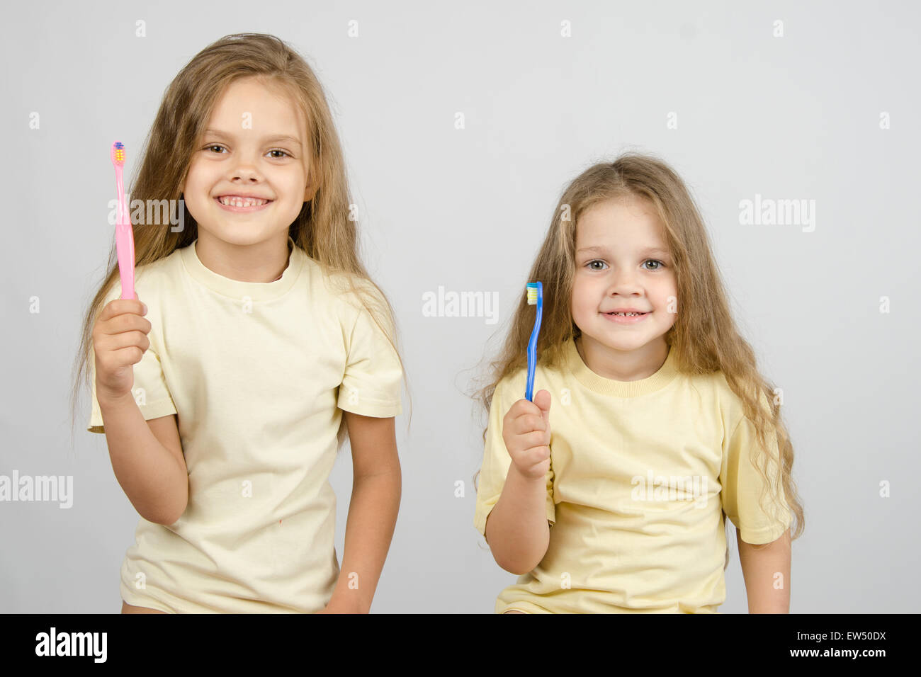 Two girls of four and six years of brushing their teeth toothbrushes ...