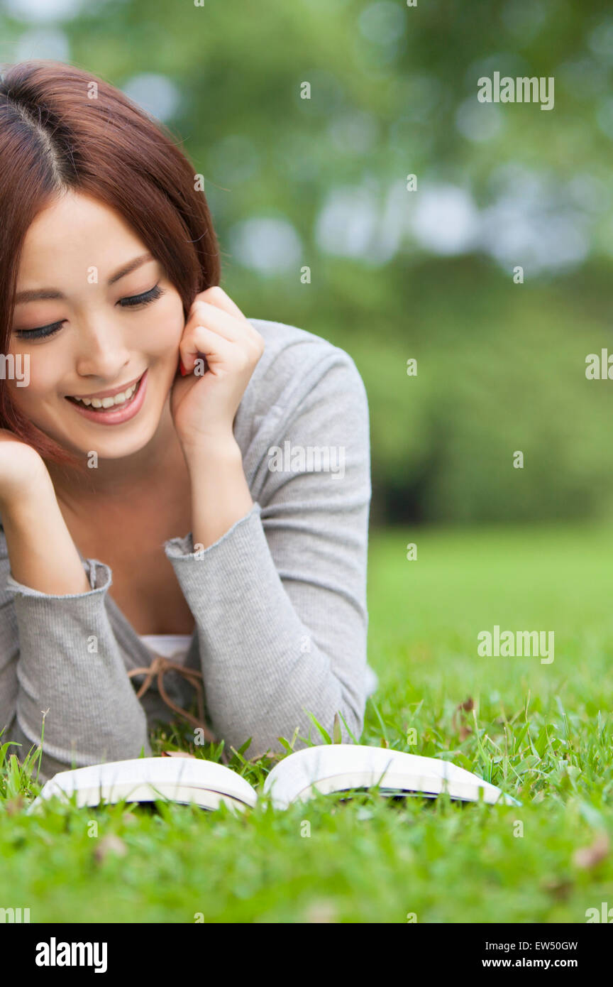 Young woman lying down on front and looking down with smile Stock Photo ...