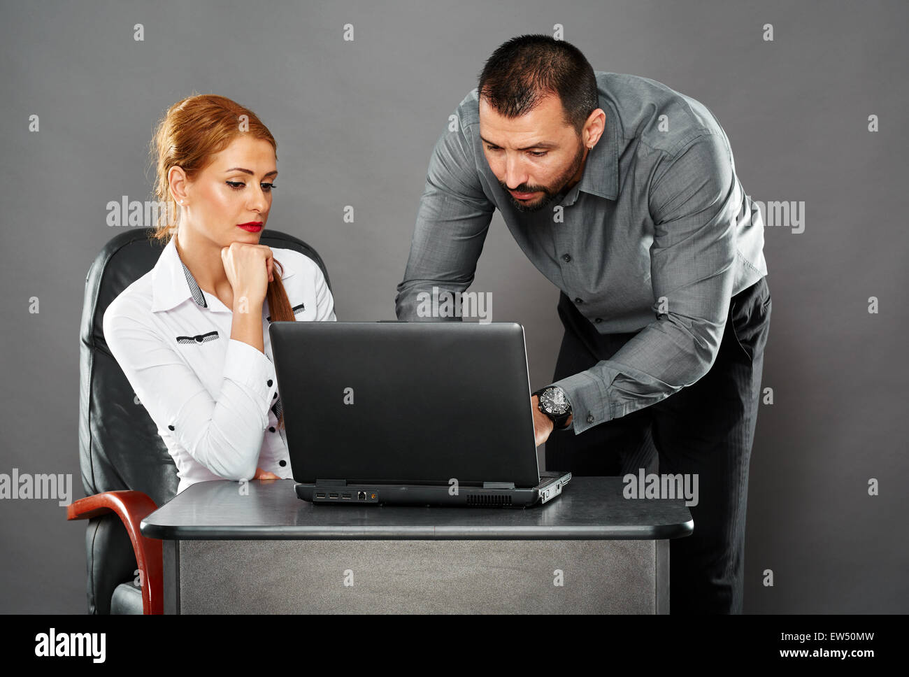 Man helping his business colleague with something on her laptop ...
