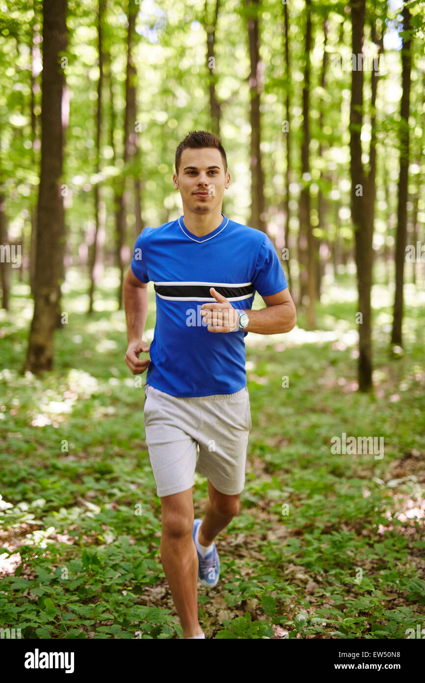 Young and fit runner on a trail run through forest Stock Photo - Alamy