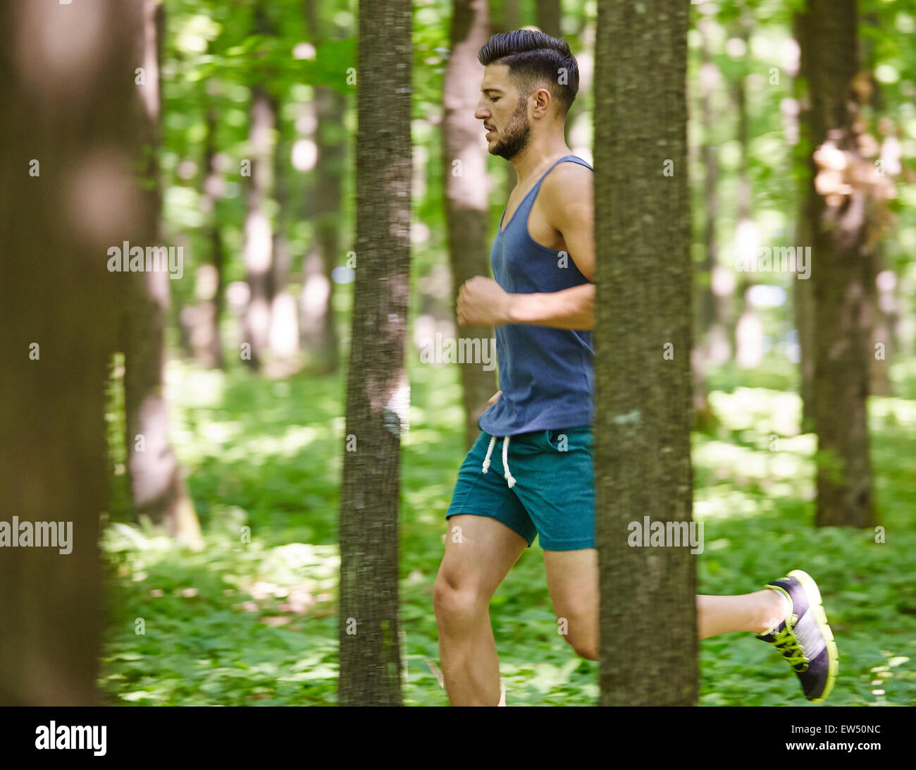 Young and fit runner on a trail run through forest Stock Photo - Alamy