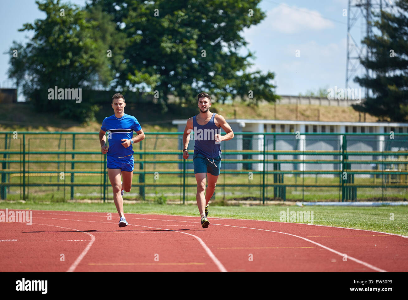 Two friends running on the lines at the stadium in a sunny day Stock ...