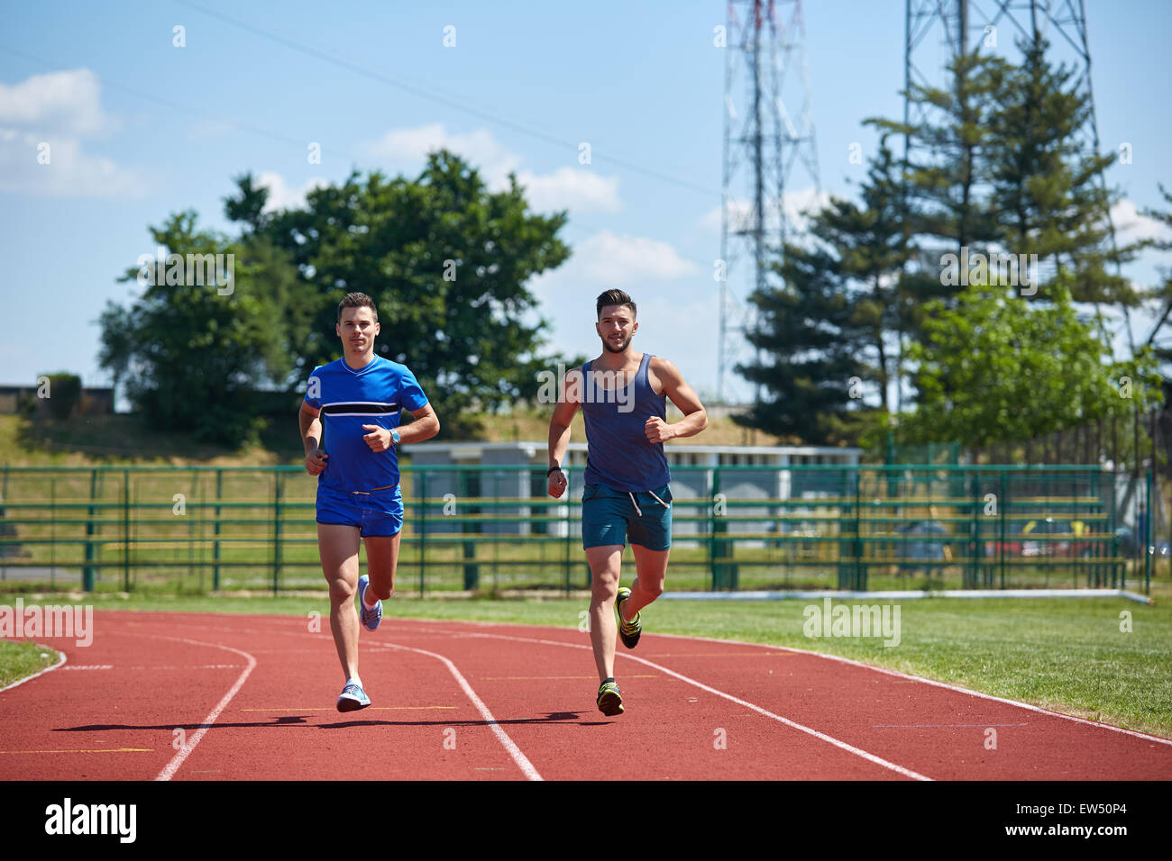Two friends running on the lines at the stadium in a sunny day Stock ...