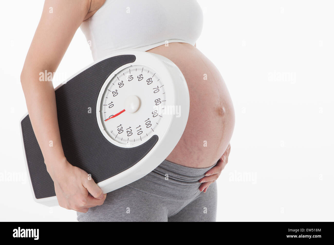 Pregnant woman holding weight scale Stock Photo - Alamy