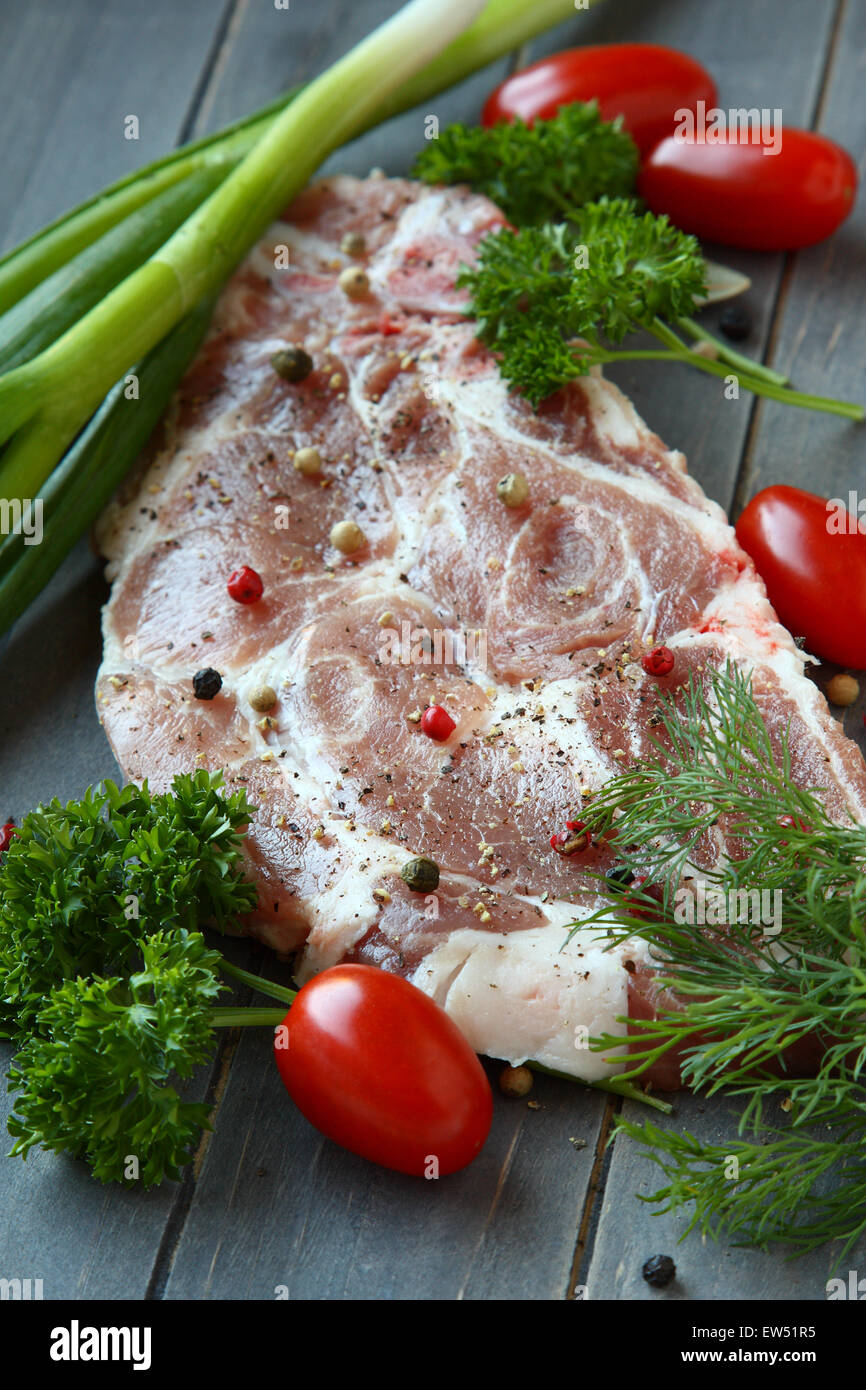 Fresh raw pork shoulder chop with spices and vegetables Stock Photo - Alamy