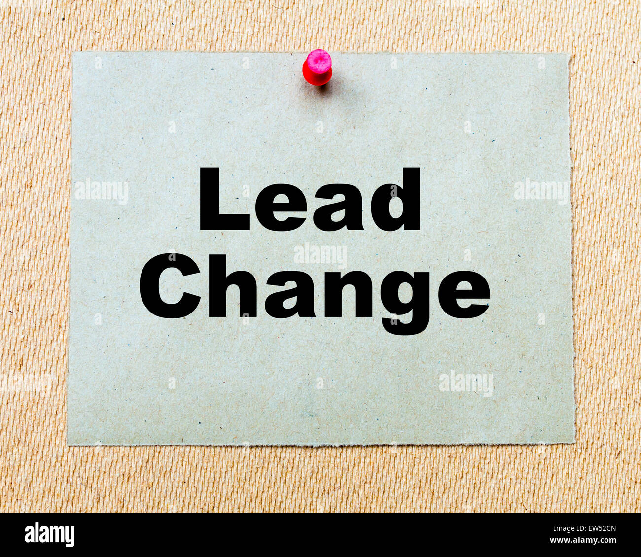 Lead Change written on paper note pinned with red thumbtack on wooden ...