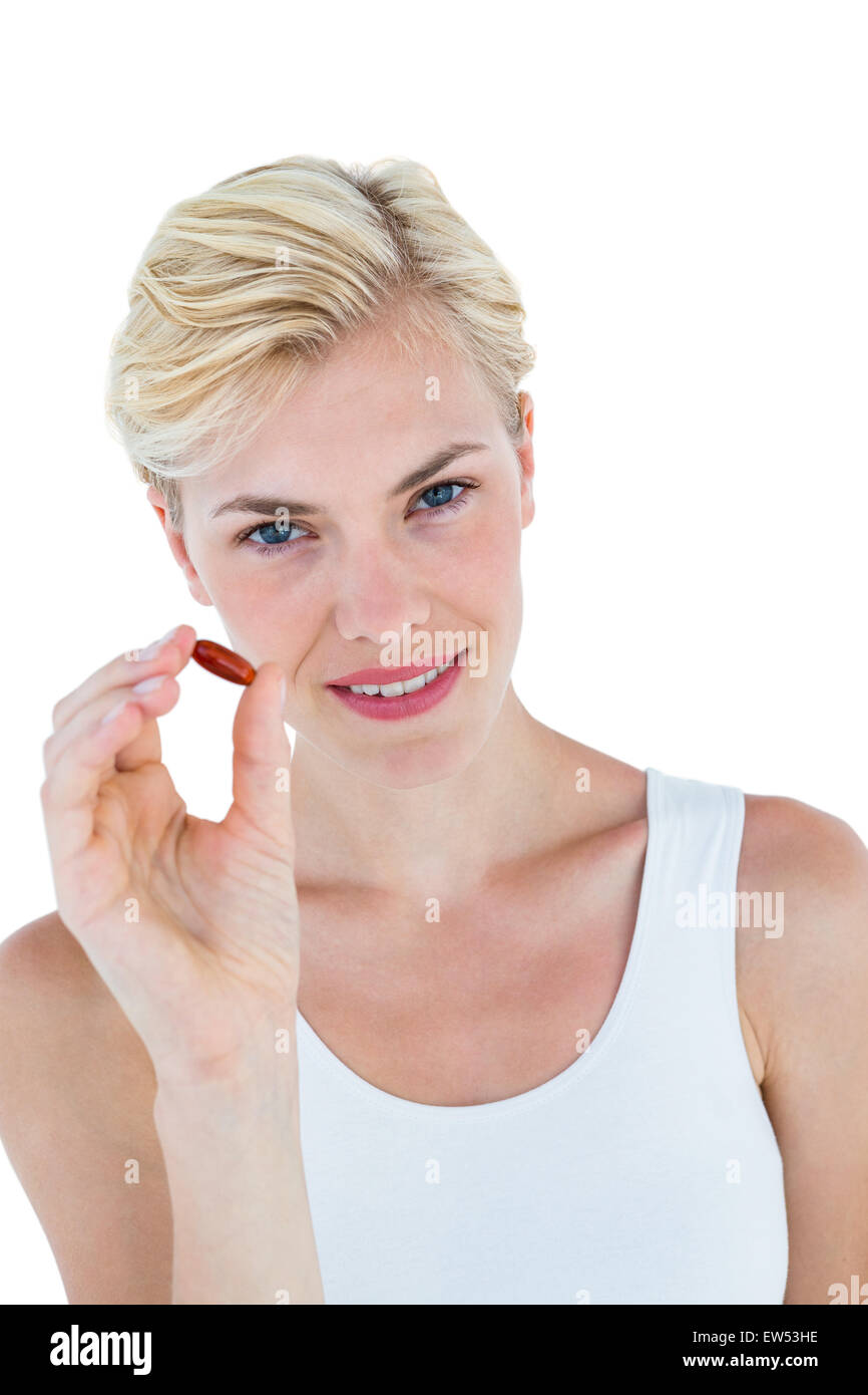 Smiling blonde woman holding red pill Stock Photo - Alamy