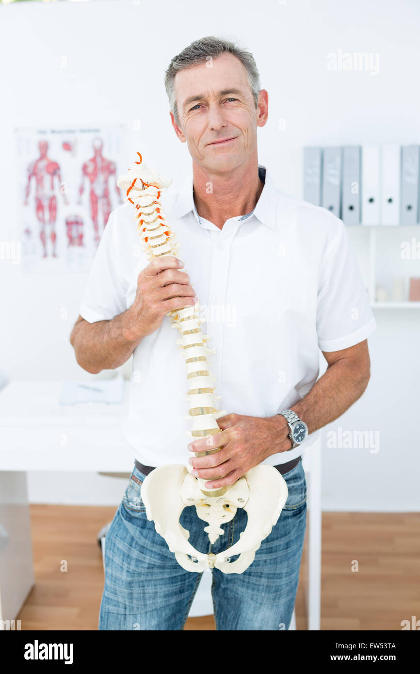 Doctor looking at camera and showing anatomical spine Stock Photo - Alamy