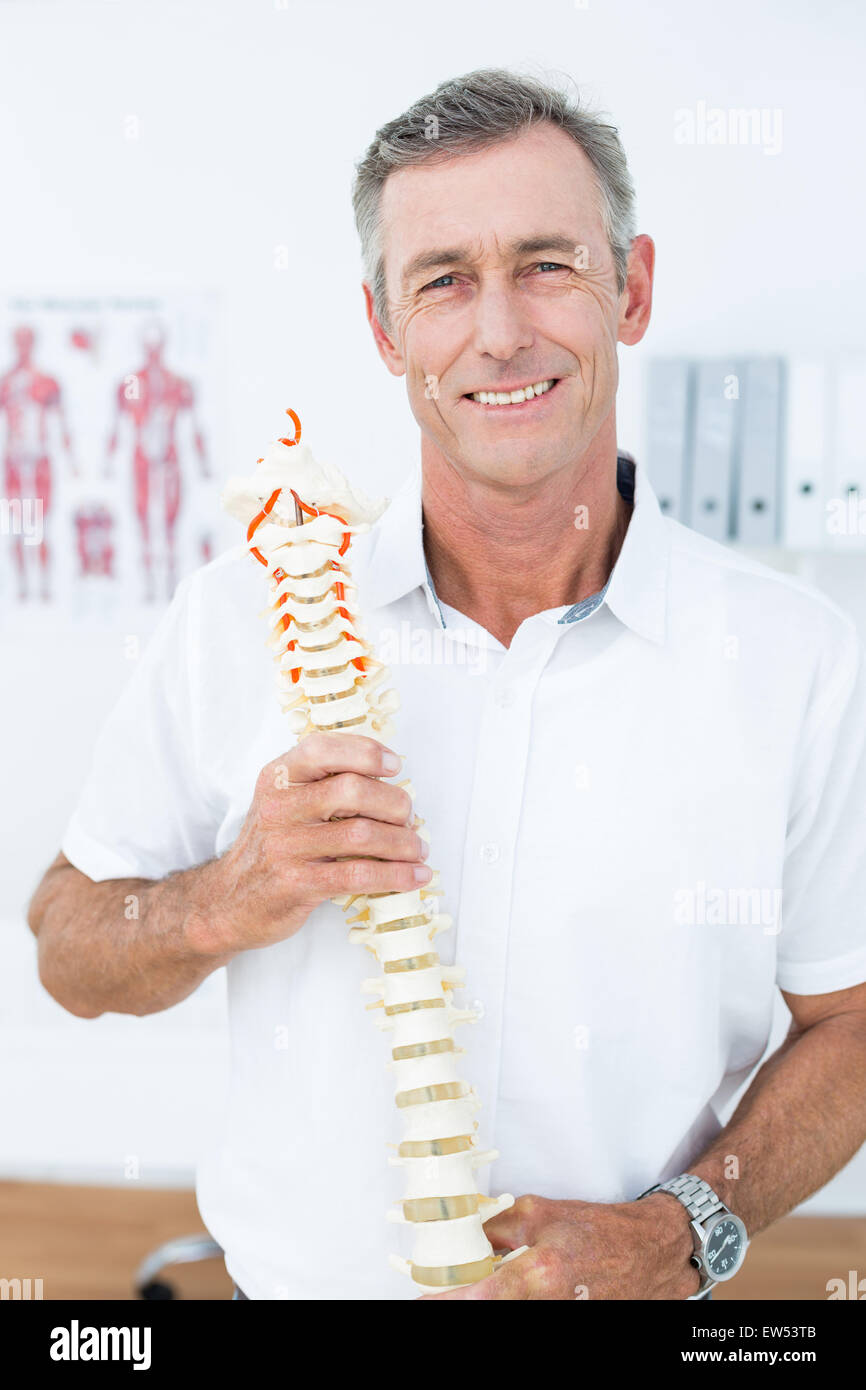 Smiling doctor showing anatomical spine Stock Photo - Alamy