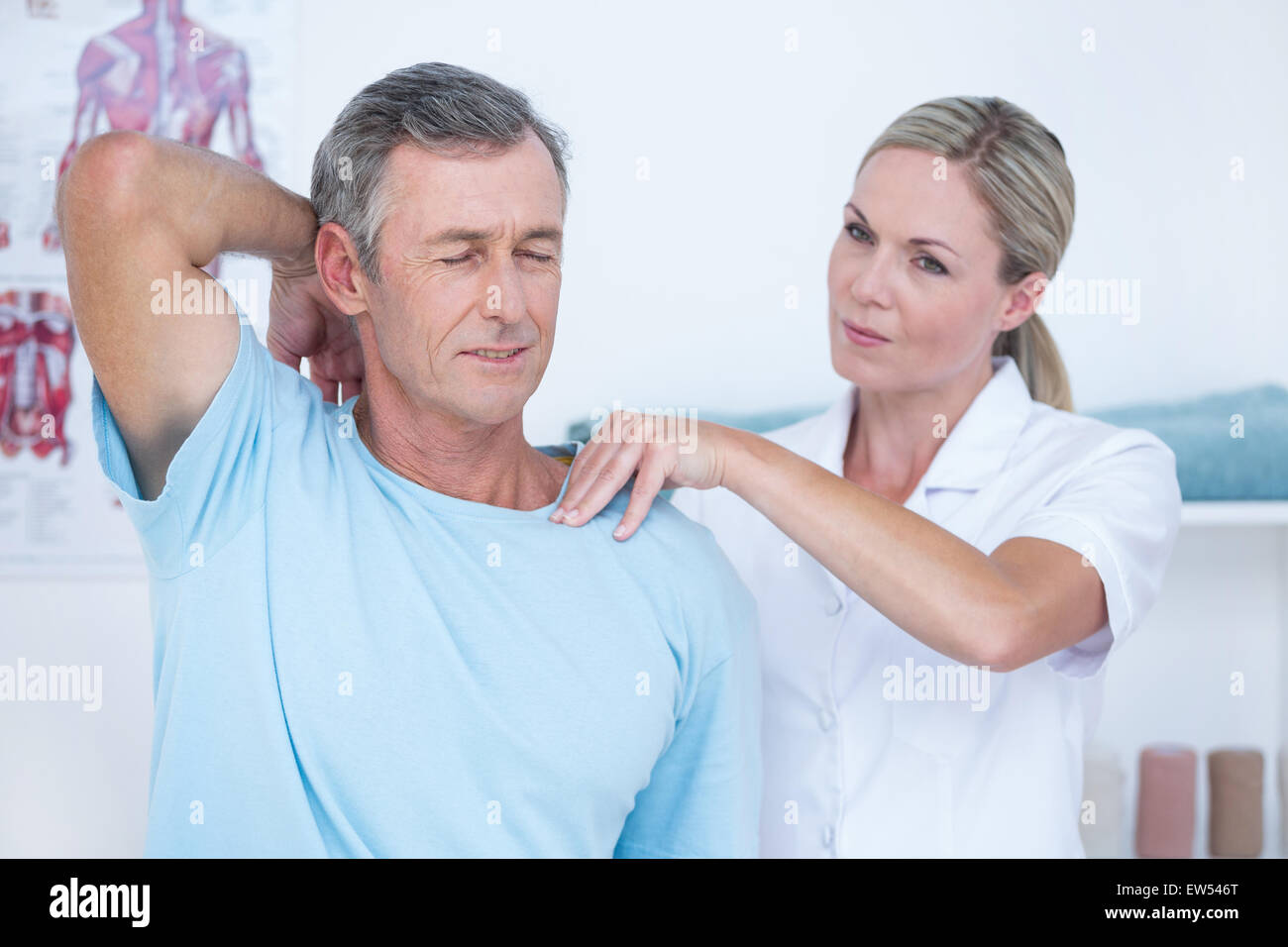 Doctor stretching a man arm Stock Photo - Alamy