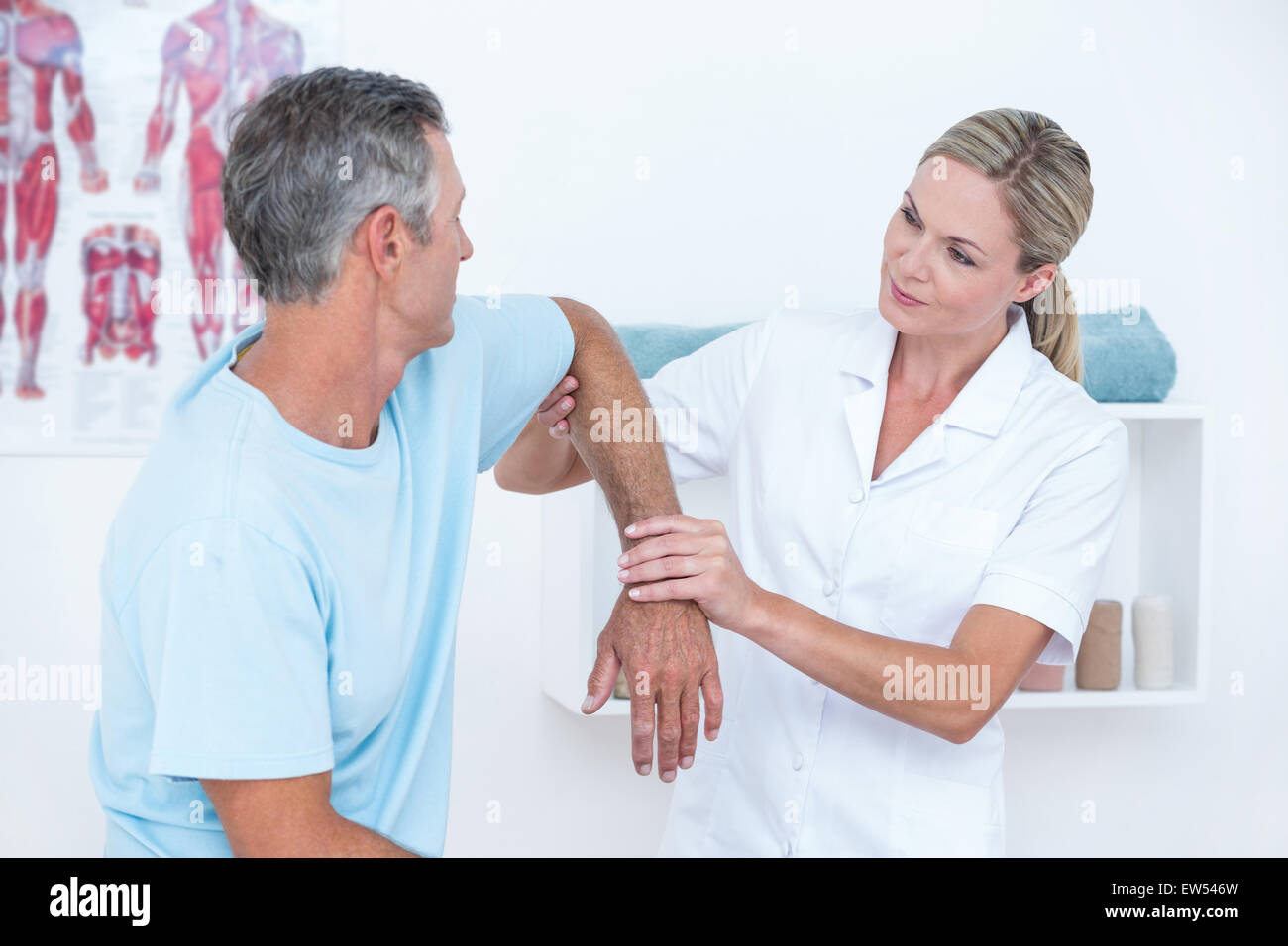 Doctor stretching a man arm Stock Photo - Alamy