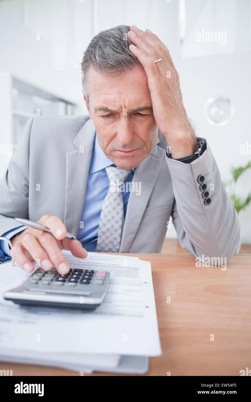 Businessman using calculator to calculate finance Stock Photo - Alamy