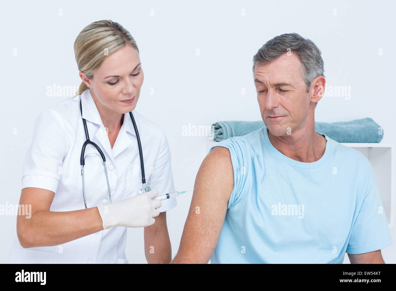 Doctor doing an injection to her patient Stock Photo - Alamy