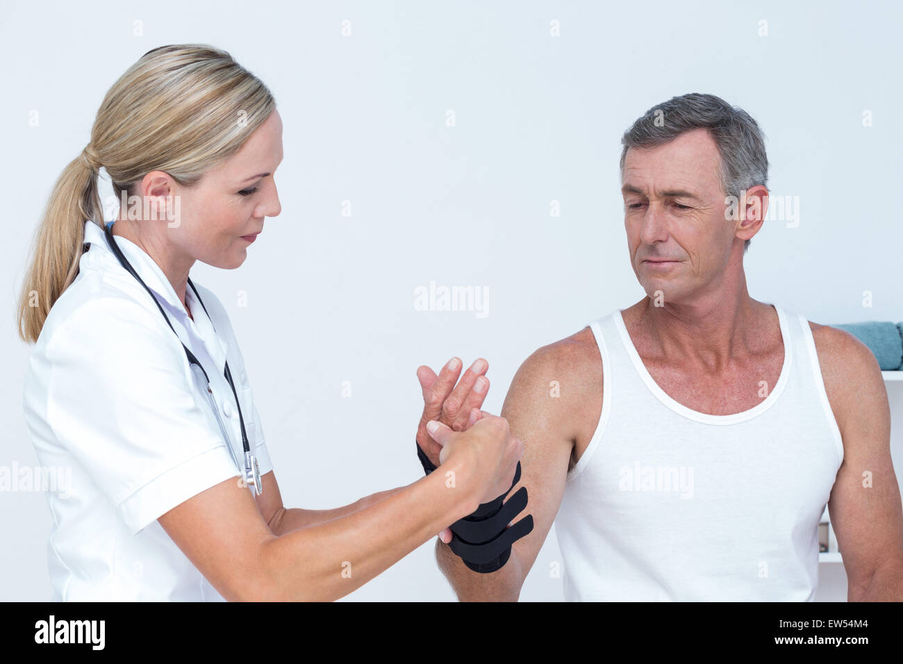 Doctor examining a man wrist Stock Photo - Alamy