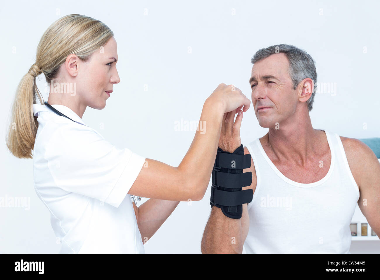 Doctor examining a man wrist Stock Photo - Alamy