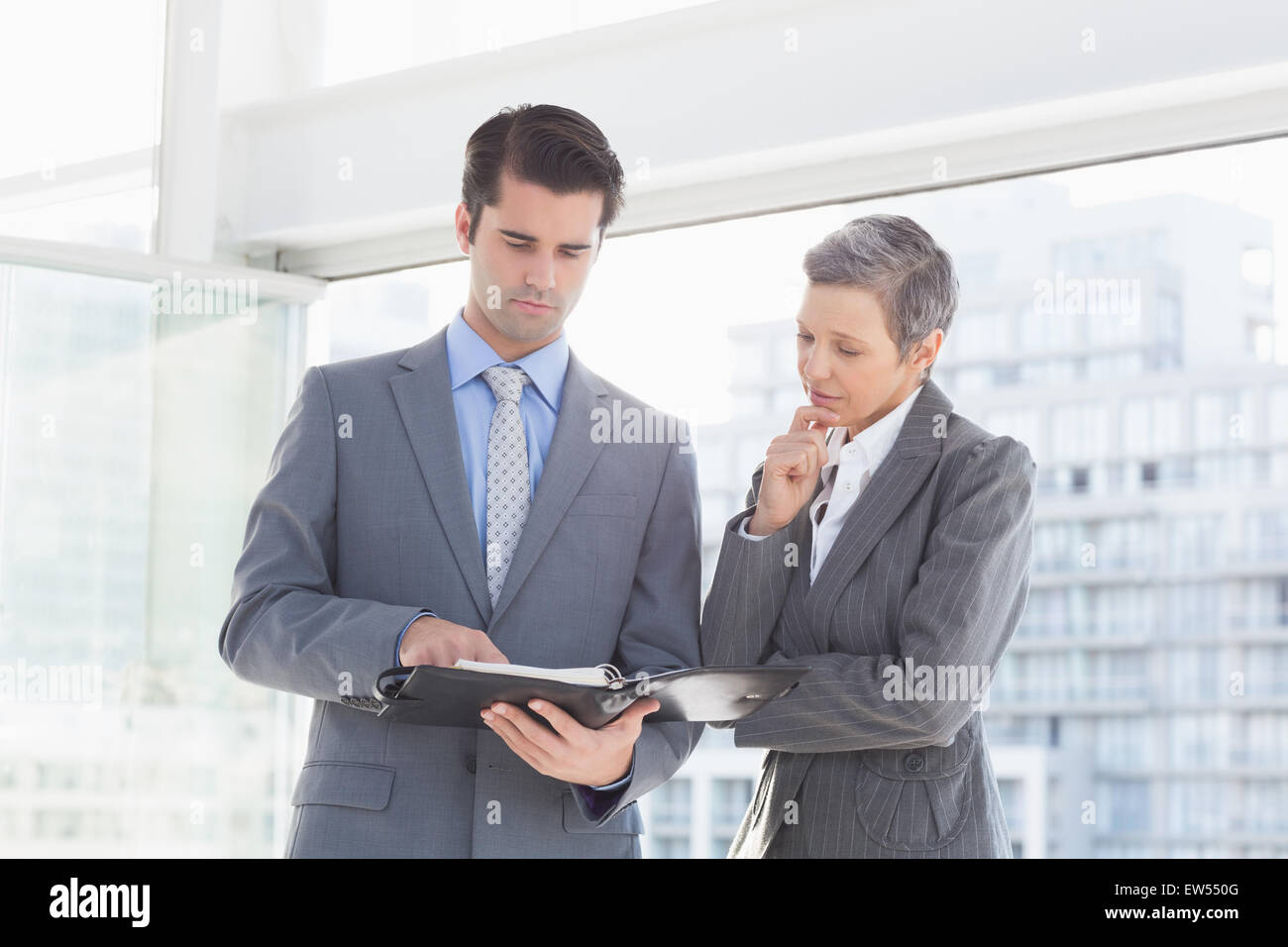 Businessman showing his notes to his colleague Stock Photo - Alamy