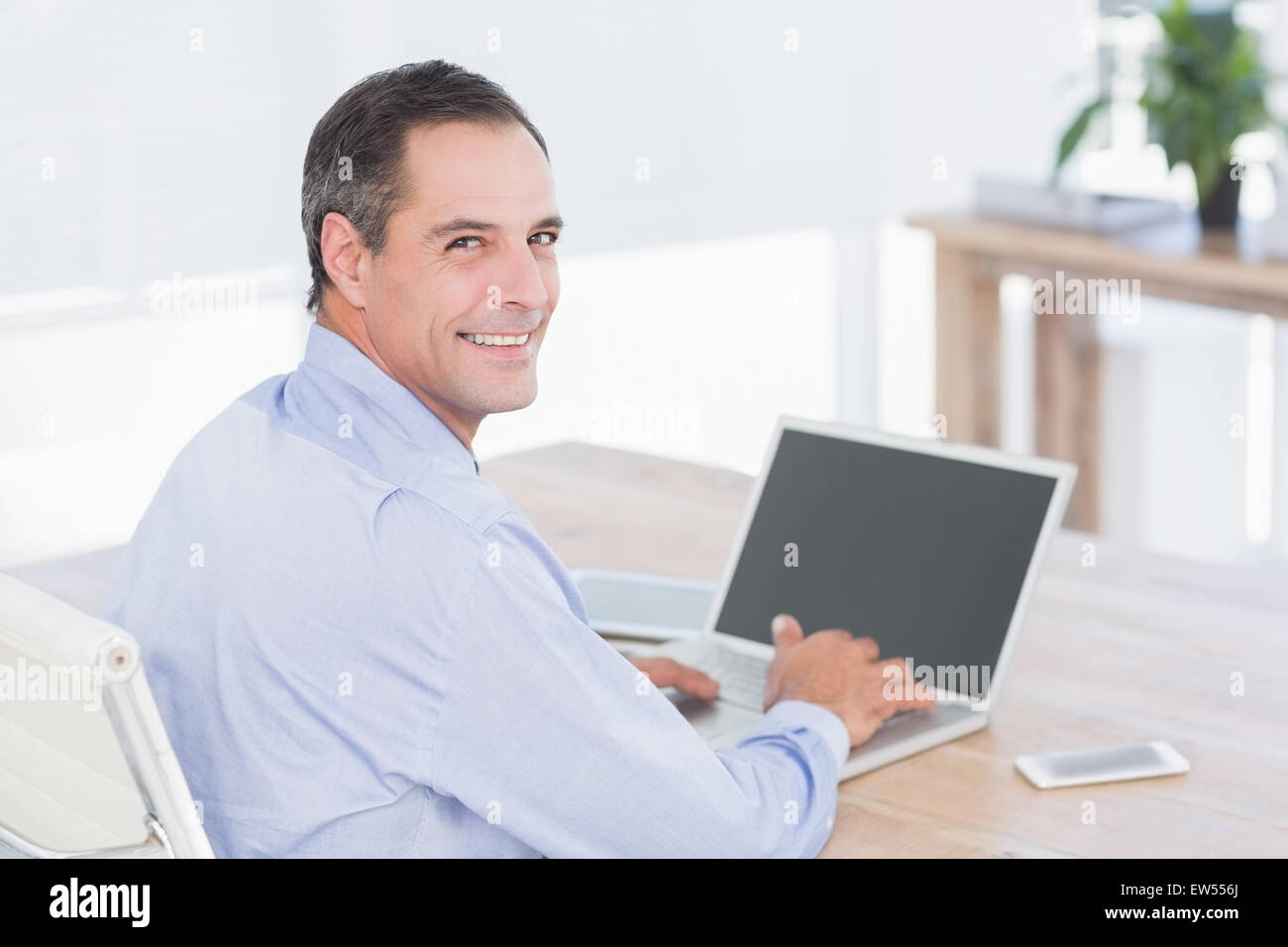 Smiling businessman using his computer Stock Photo - Alamy