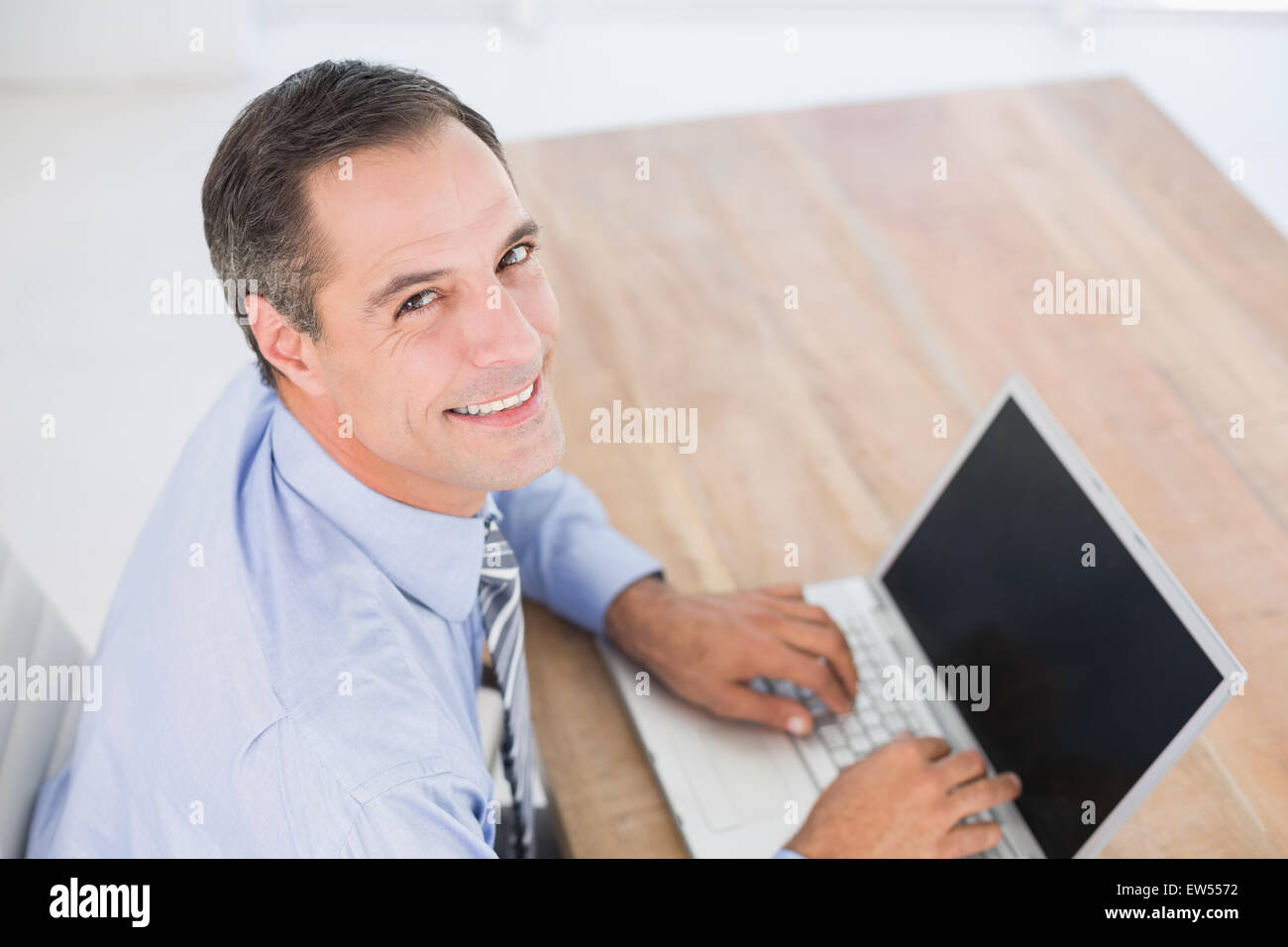Smiling businessman using his computer Stock Photo - Alamy