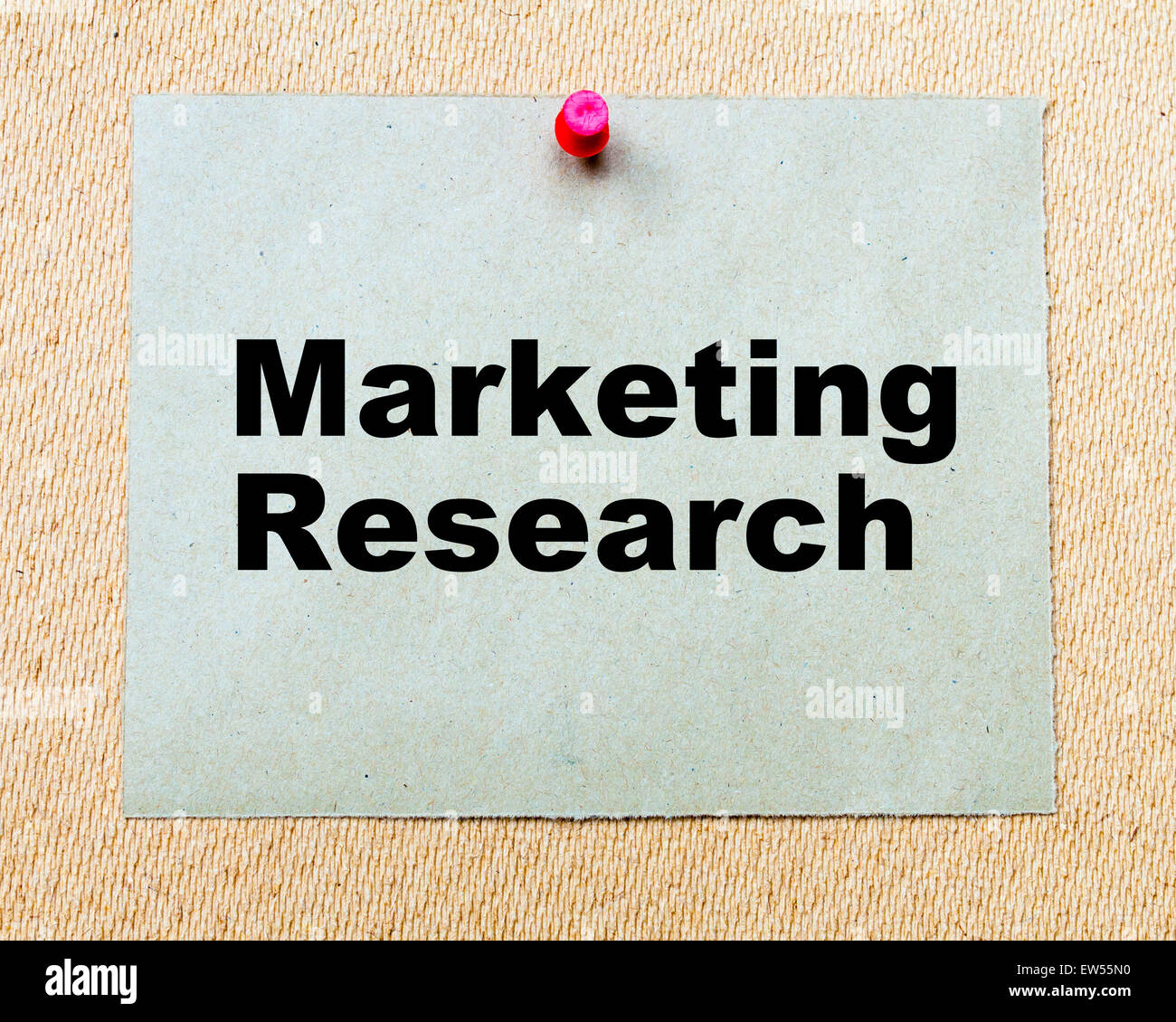 Marketing Research written on paper note pinned with red thumbtack on ...