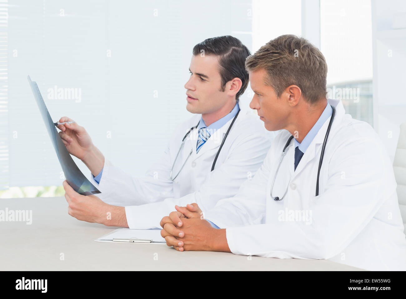 Concentrated doctors looking at Xray Stock Photo - Alamy