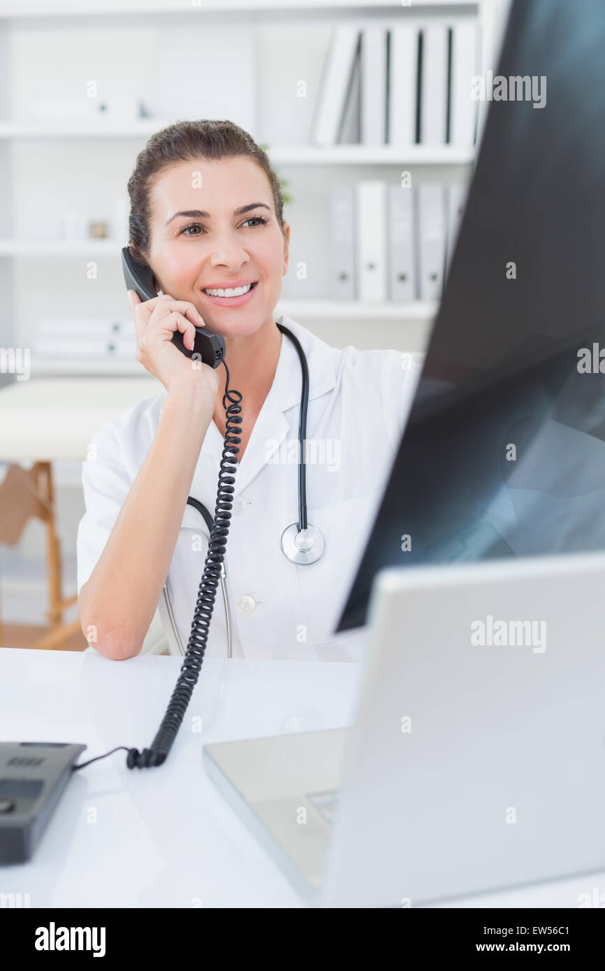 Doctor doing phone call while she using computer Stock Photo - Alamy